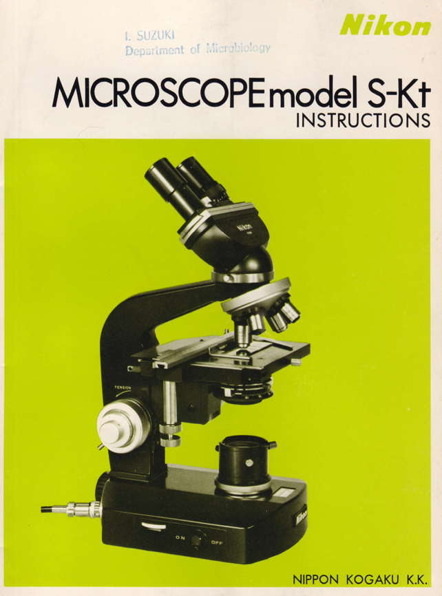 A black microscope with a green backgroundDescription automatically ...